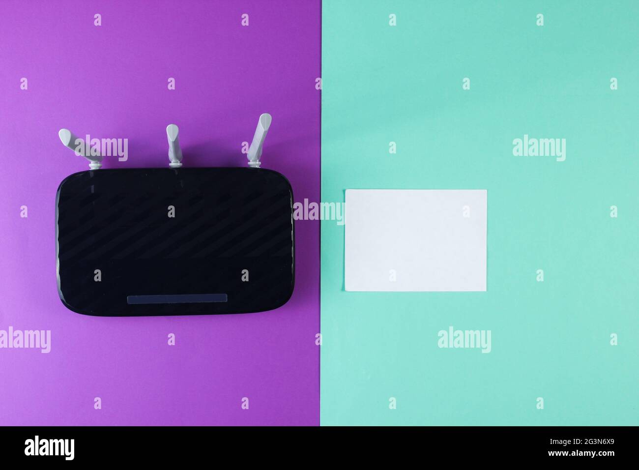 Three antenna wi-fi router with white sheet of paper on purple blue ...