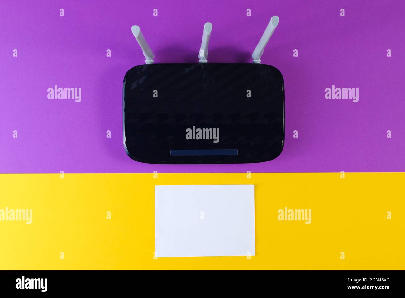 Three antenna wi-fi router with white sheet of paper on purple yellow ...