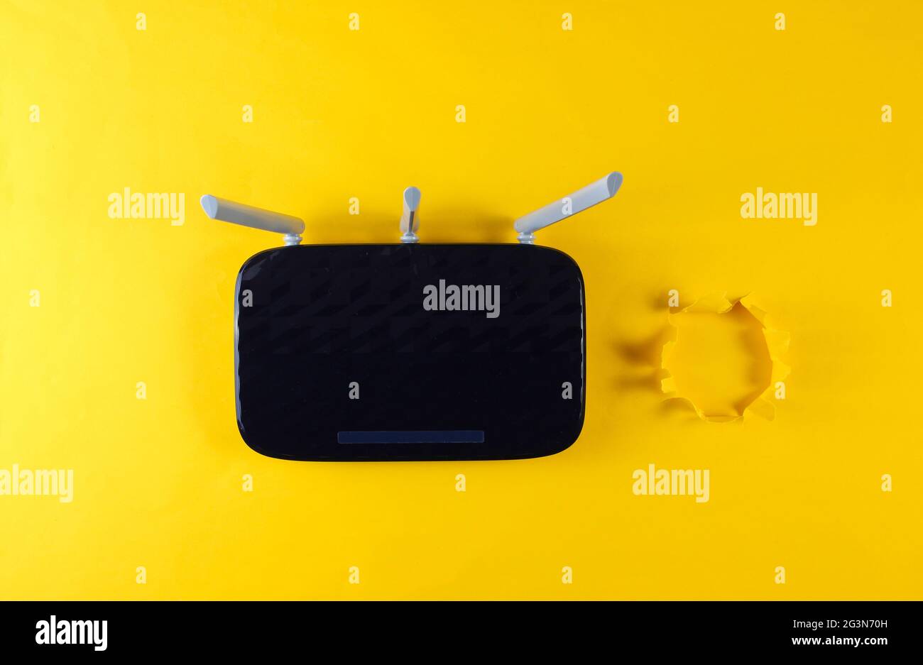 Wi-Fi router on a yellow background with torn hole Stock Photo - Alamy