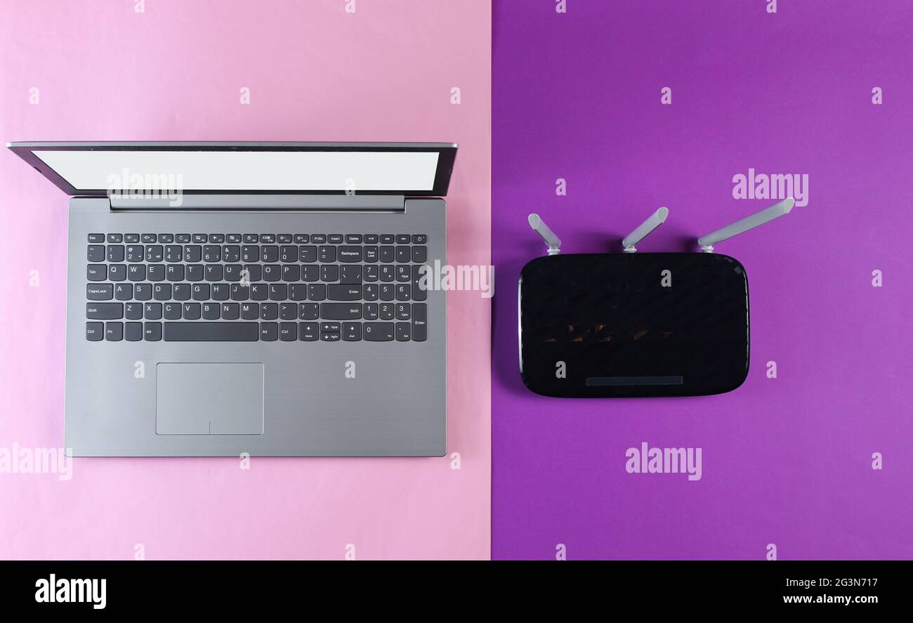 Wi fi router, laptop on purple background. Modern gadgets. Top view ...