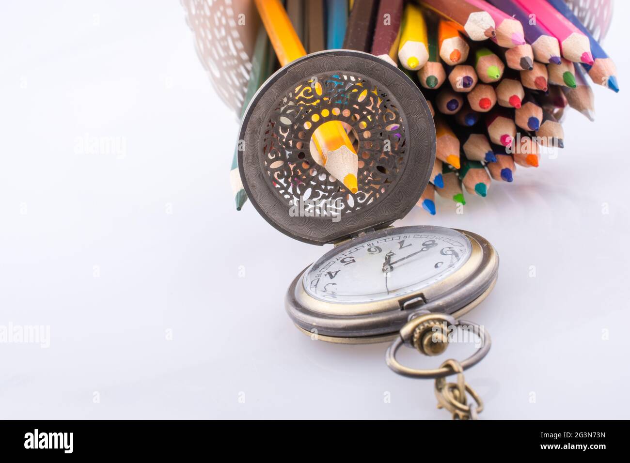 Retro style pocket watch and color pencils Stock Photo - Alamy