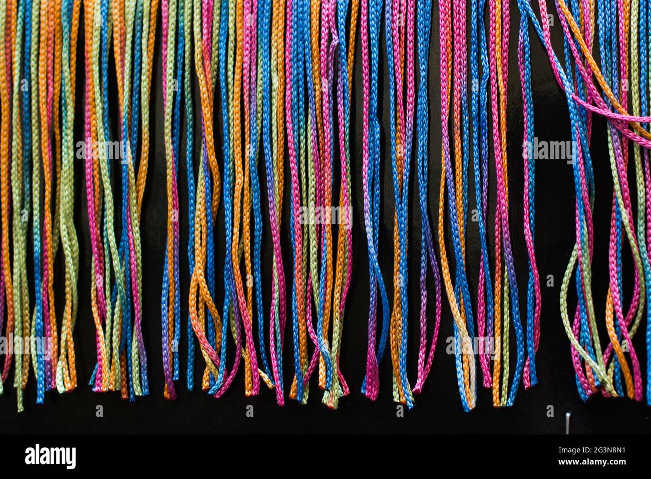 Lots of colorful braided strings on display Stock Photo - Alamy
