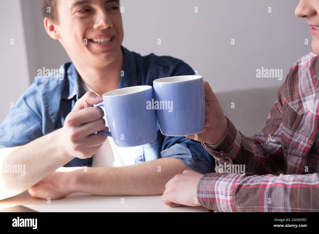 Two boys drinking coffee together Stock Photo - Alamy