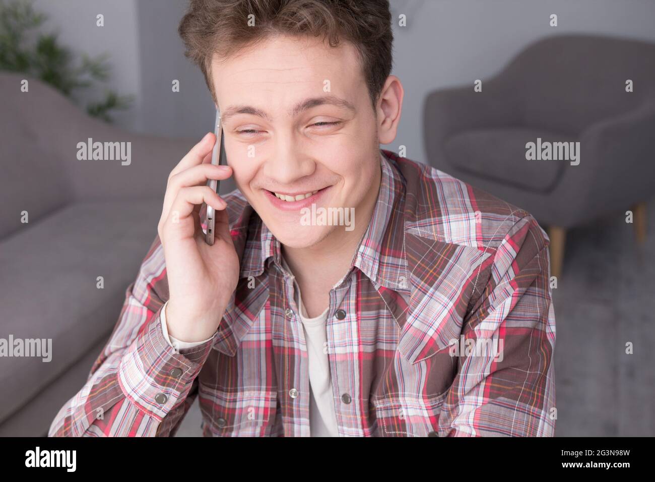 Teenage guy using phone while studying Stock Photo - Alamy