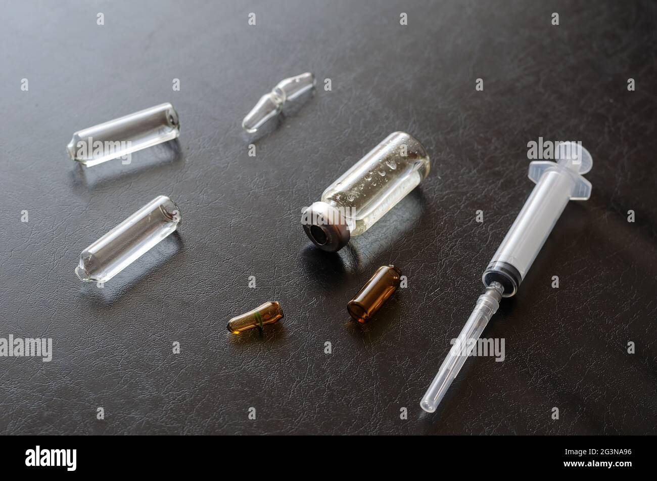 A syringe, three ampoules, and a bottle of white powder. Glass ampoules ...