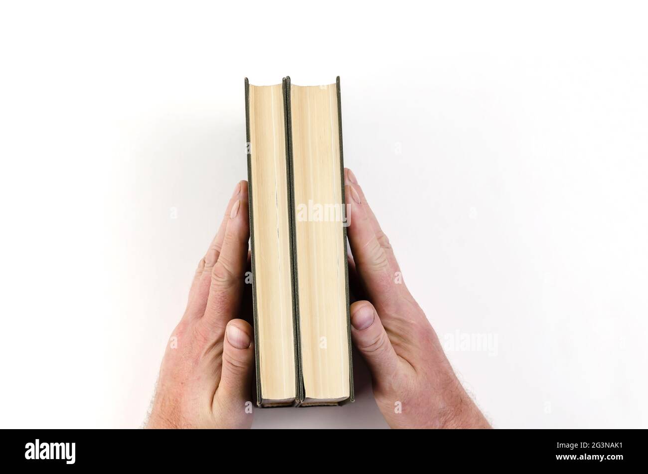 Hands holding green hardcover books on a white background. A man ...