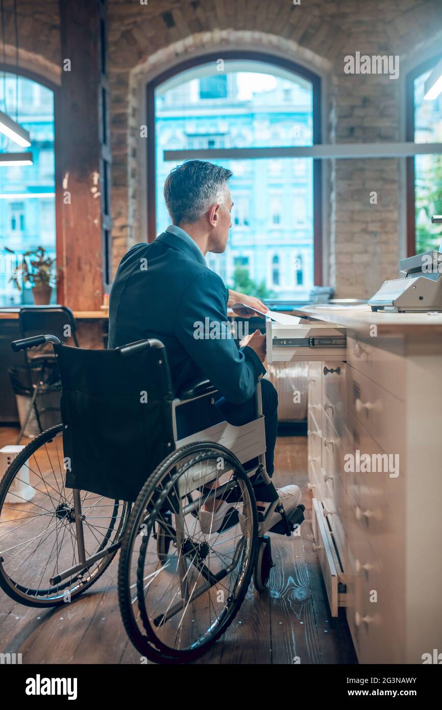 Back view of man in wheelchair indoors Stock Photo - Alamy