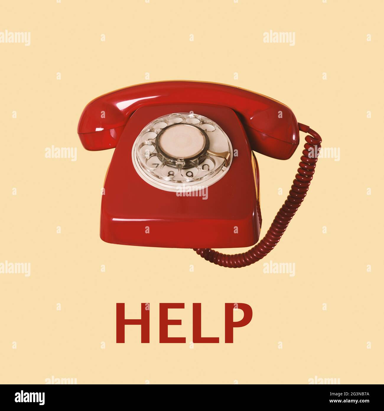 a red landline rotary dial telephone and the text help on a beige ...
