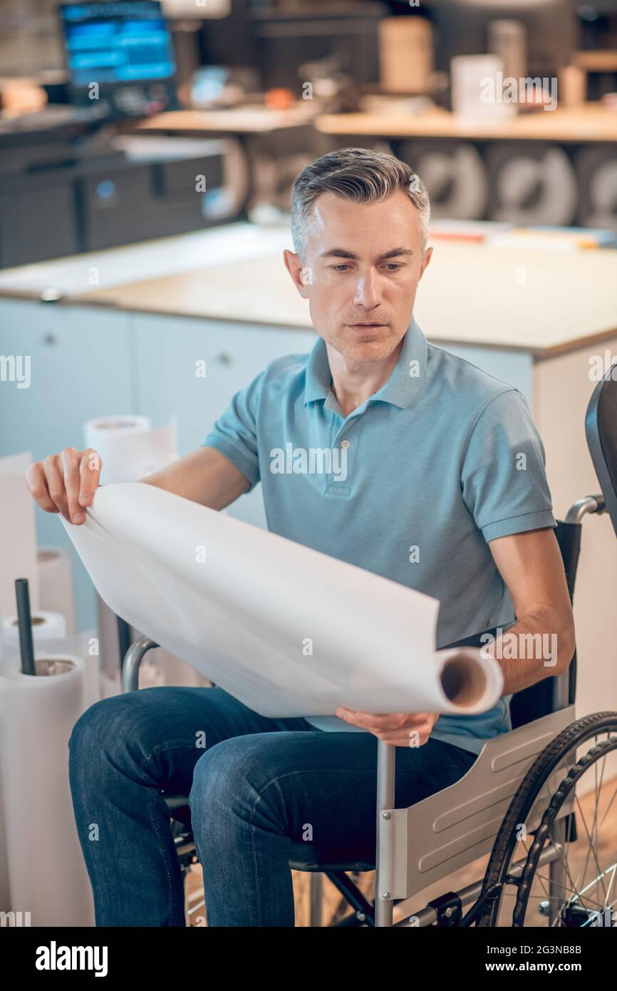Man with disabilities sitting on wheelchair in office Stock Photo - Alamy
