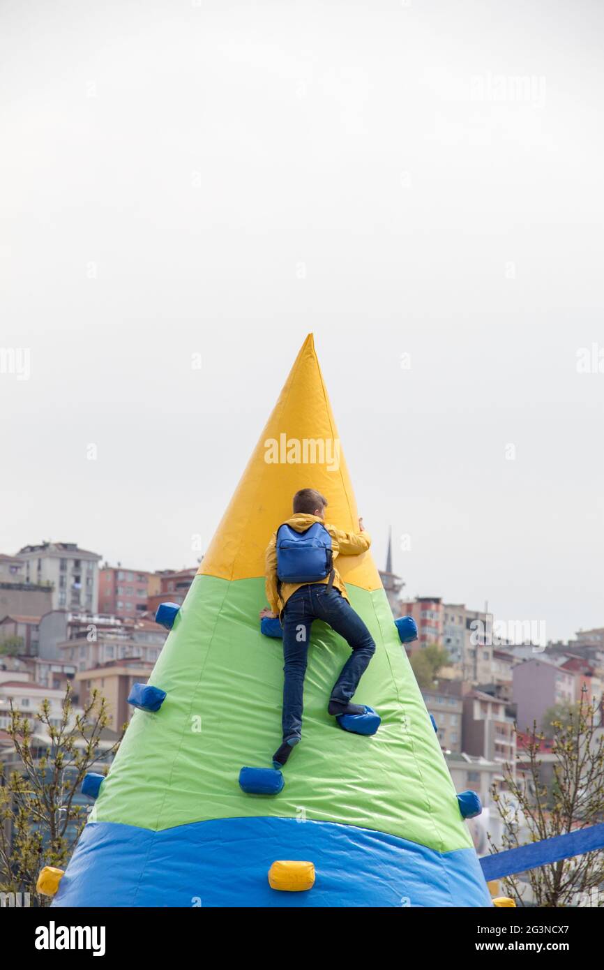 Boy climbing on cone shaped climbing course Stock Photo - Alamy