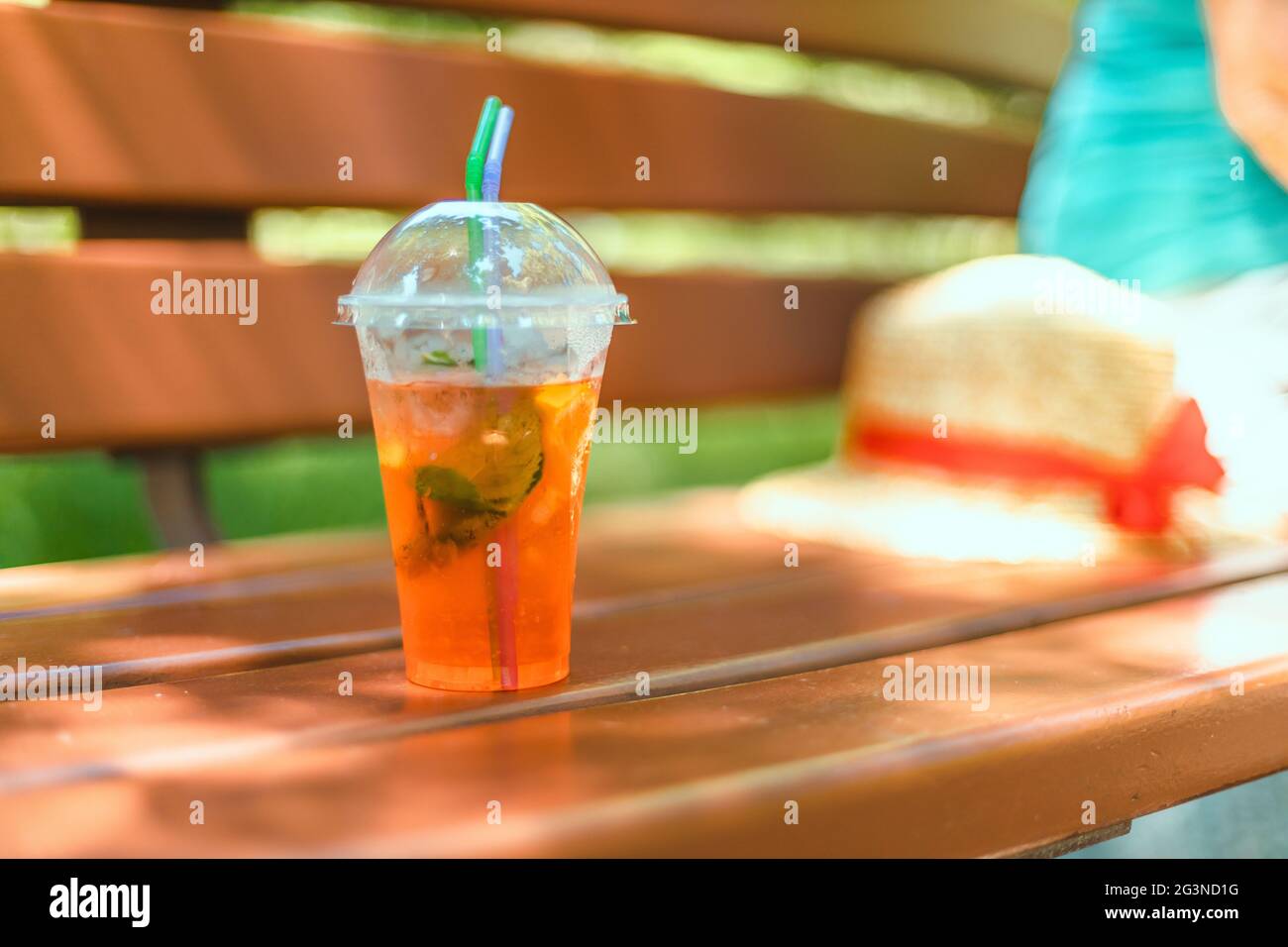 Close up takeaway plastic cup with aperol spritz cocktail on wooden ...