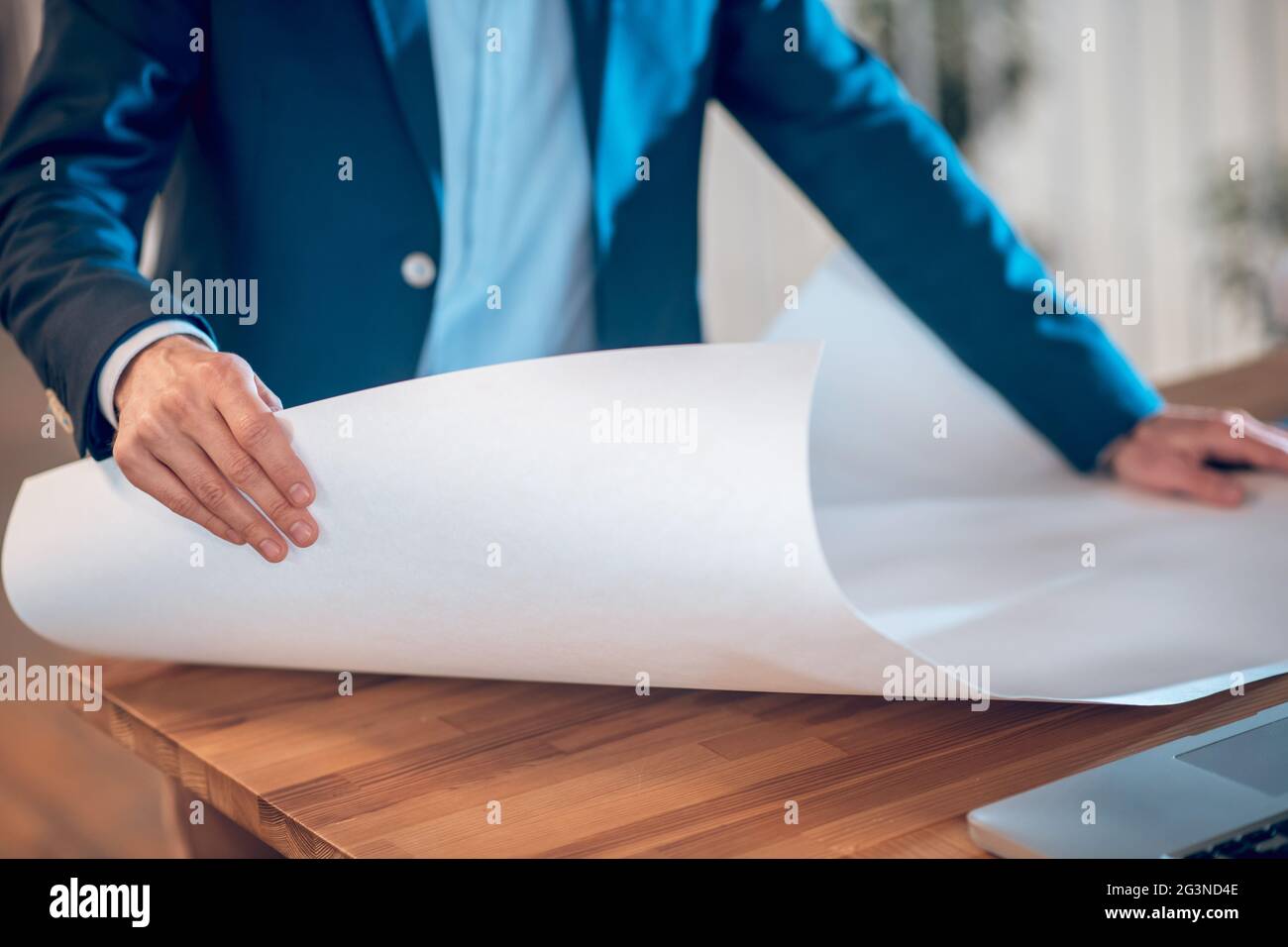 Male hands unrolling sheet of paper with sketch Stock Photo - Alamy