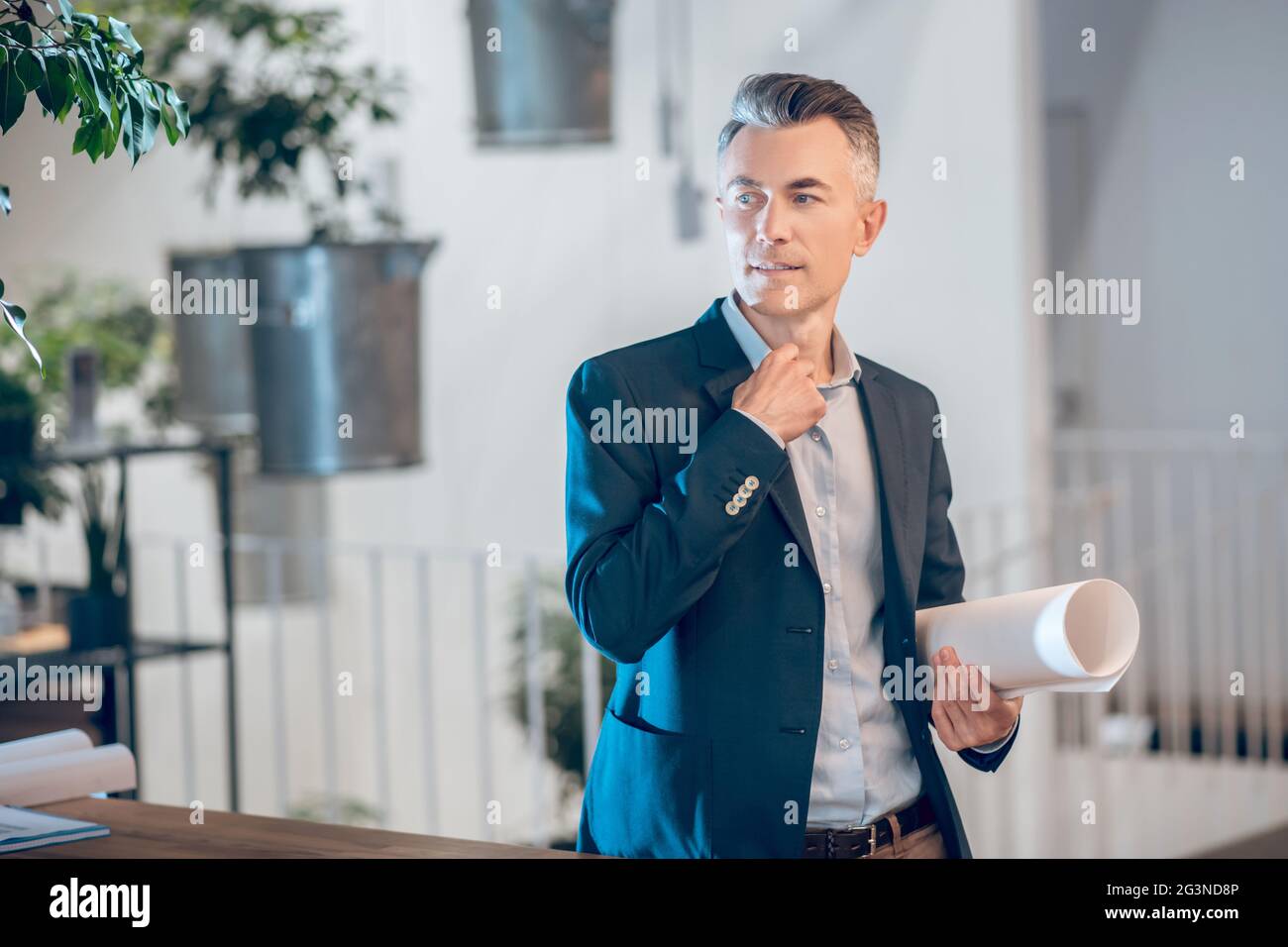 Confident man with sketch standing in office space Stock Photo - Alamy