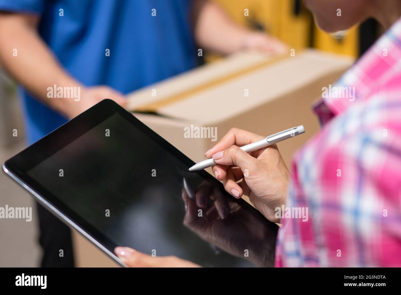 Female client signs for delivery in tablet app Stock Photo - Alamy