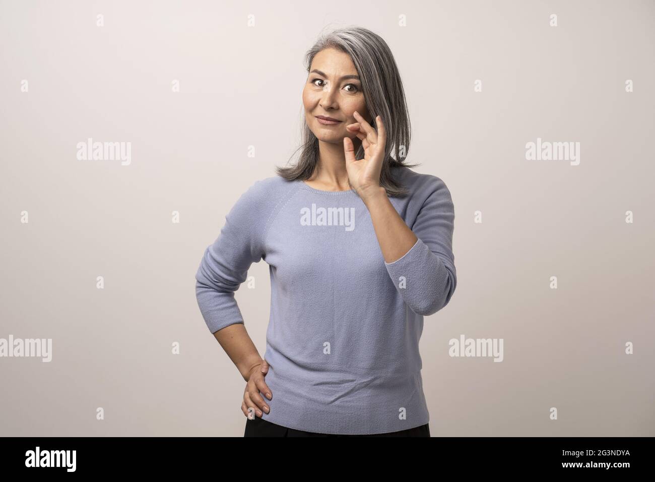 Smiling Asian woman touches her grey hair Stock Photo - Alamy