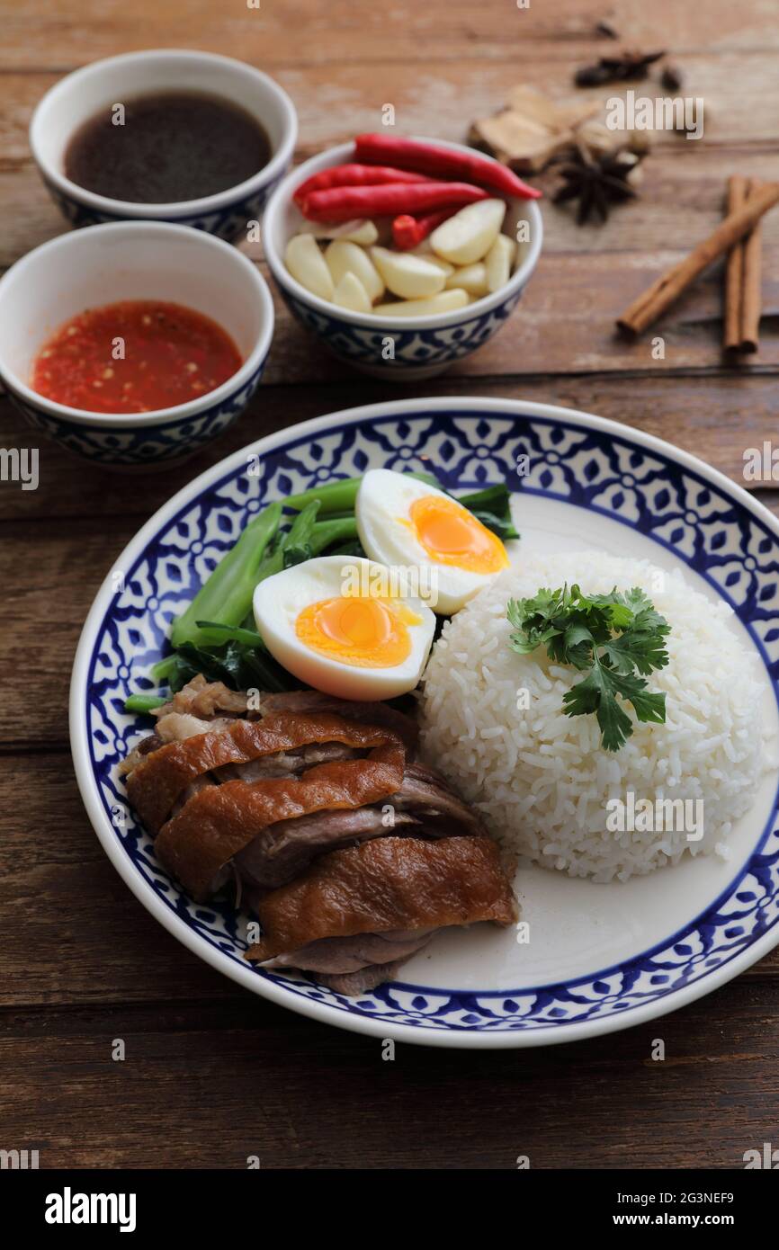 Local Thai food stewed pork leg on rice isolated in wood background ...