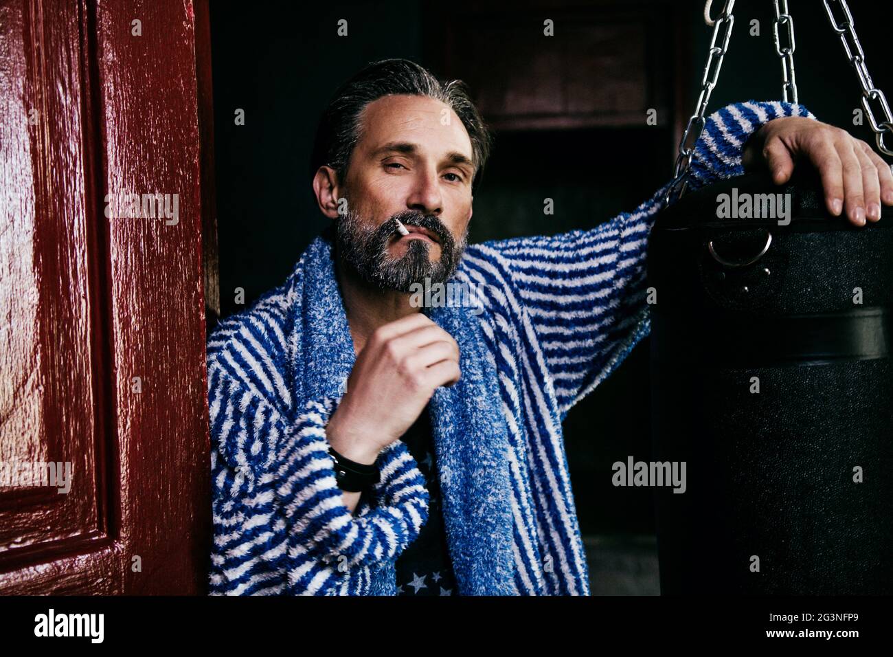 Handsome drunk man smokes and leans on a punching boxing bag Stock ...
