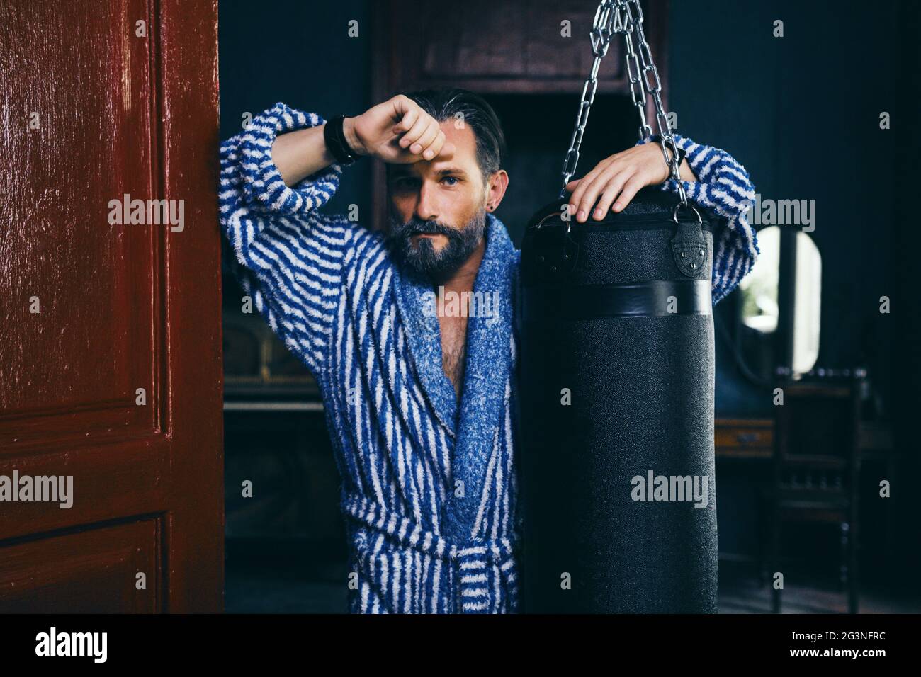 Handsome drunk man leans on a punching boxing bag Stock Photo - Alamy