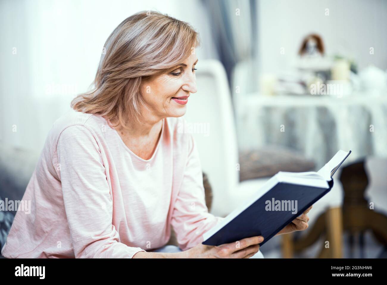 Beautiful mature woman is reading a book Stock Photo - Alamy