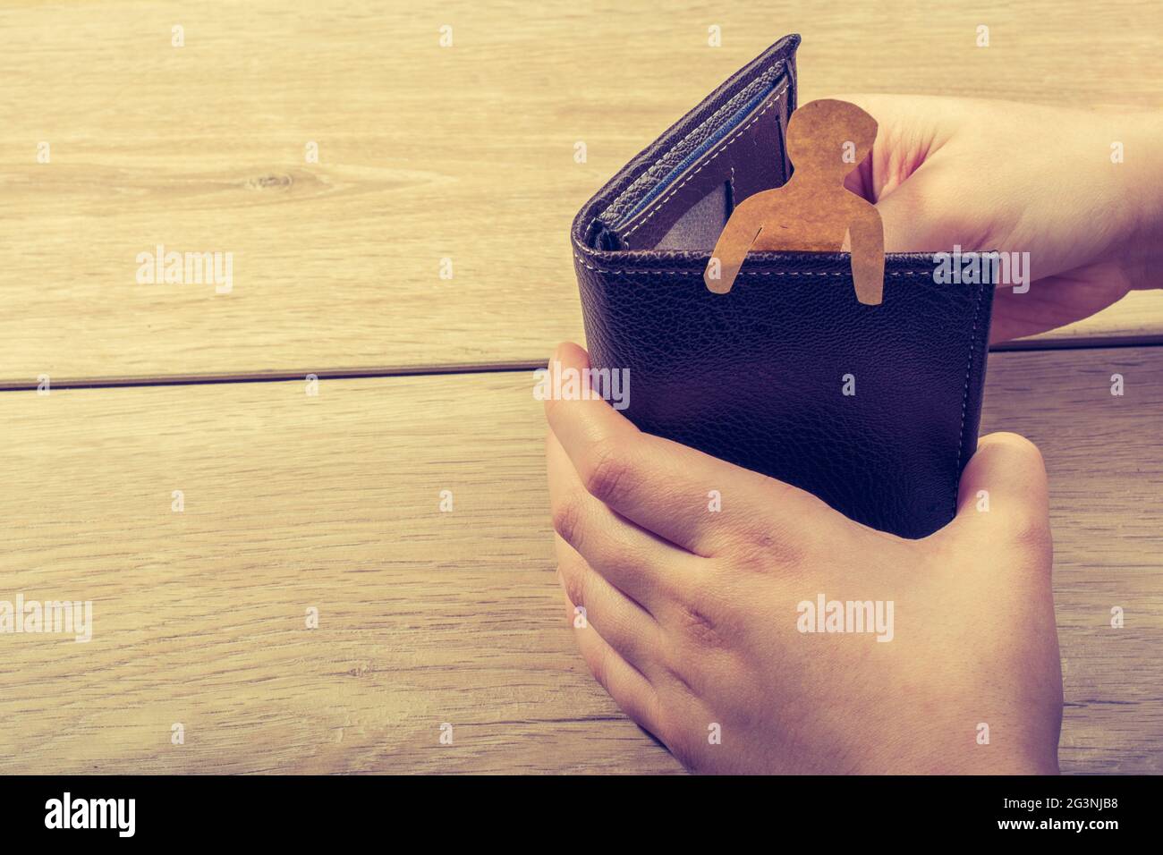 Paper man shape in wallet in hand Stock Photo - Alamy