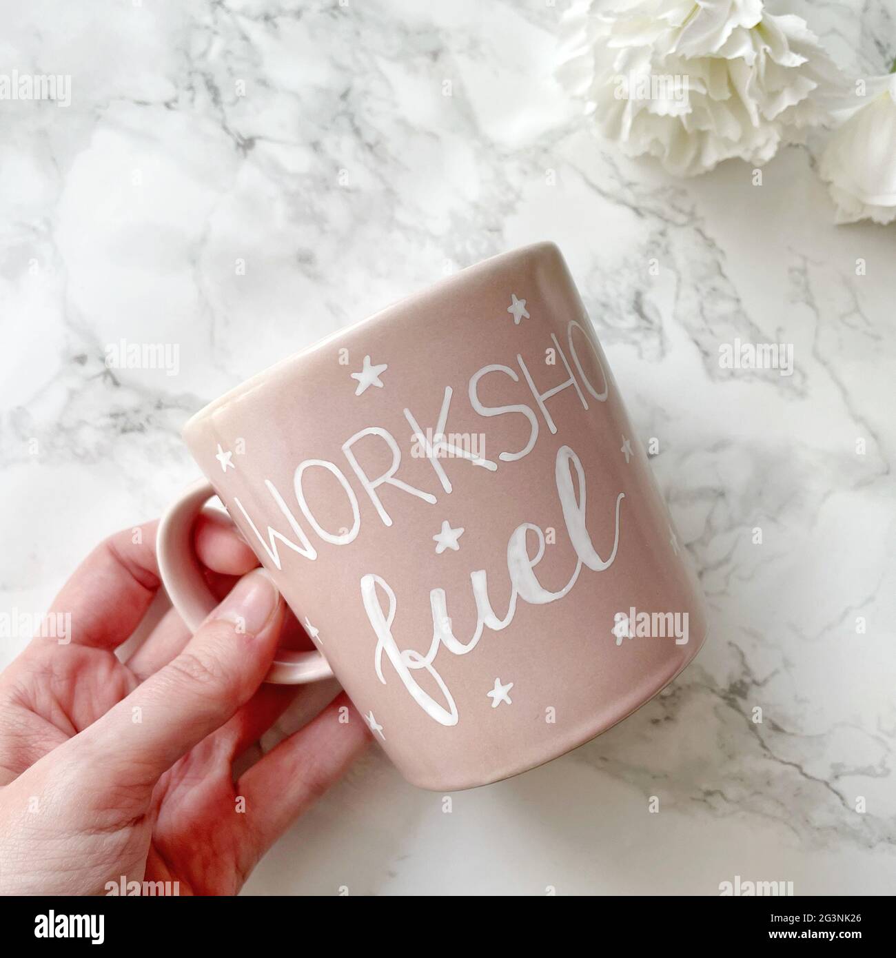 Custom calligraphy project made on pink coffee mug with quote "Workshop ...