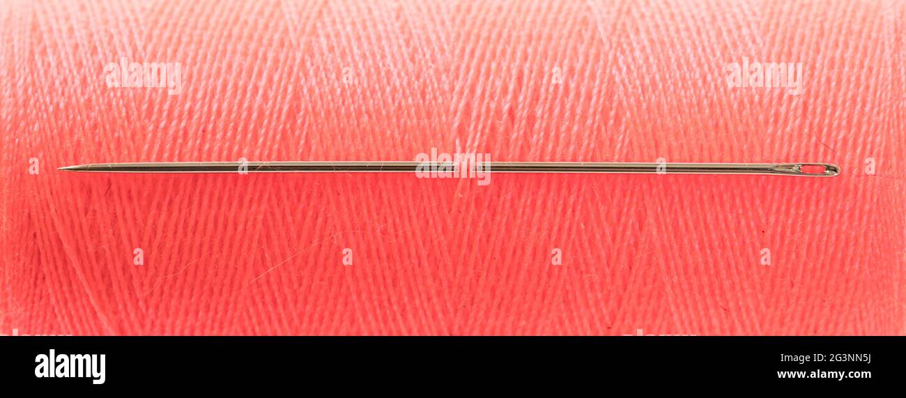 Red threat with needle Stock Photo - Alamy