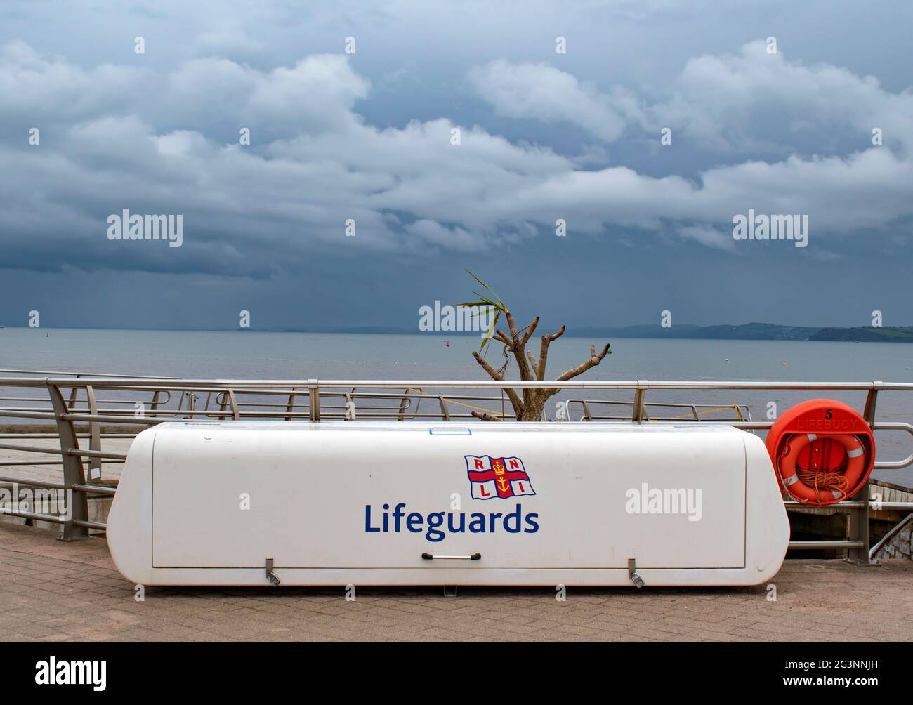Emouth, UK - May 17th 2021: Lifeguards sign next to a red lifebuoy on ...