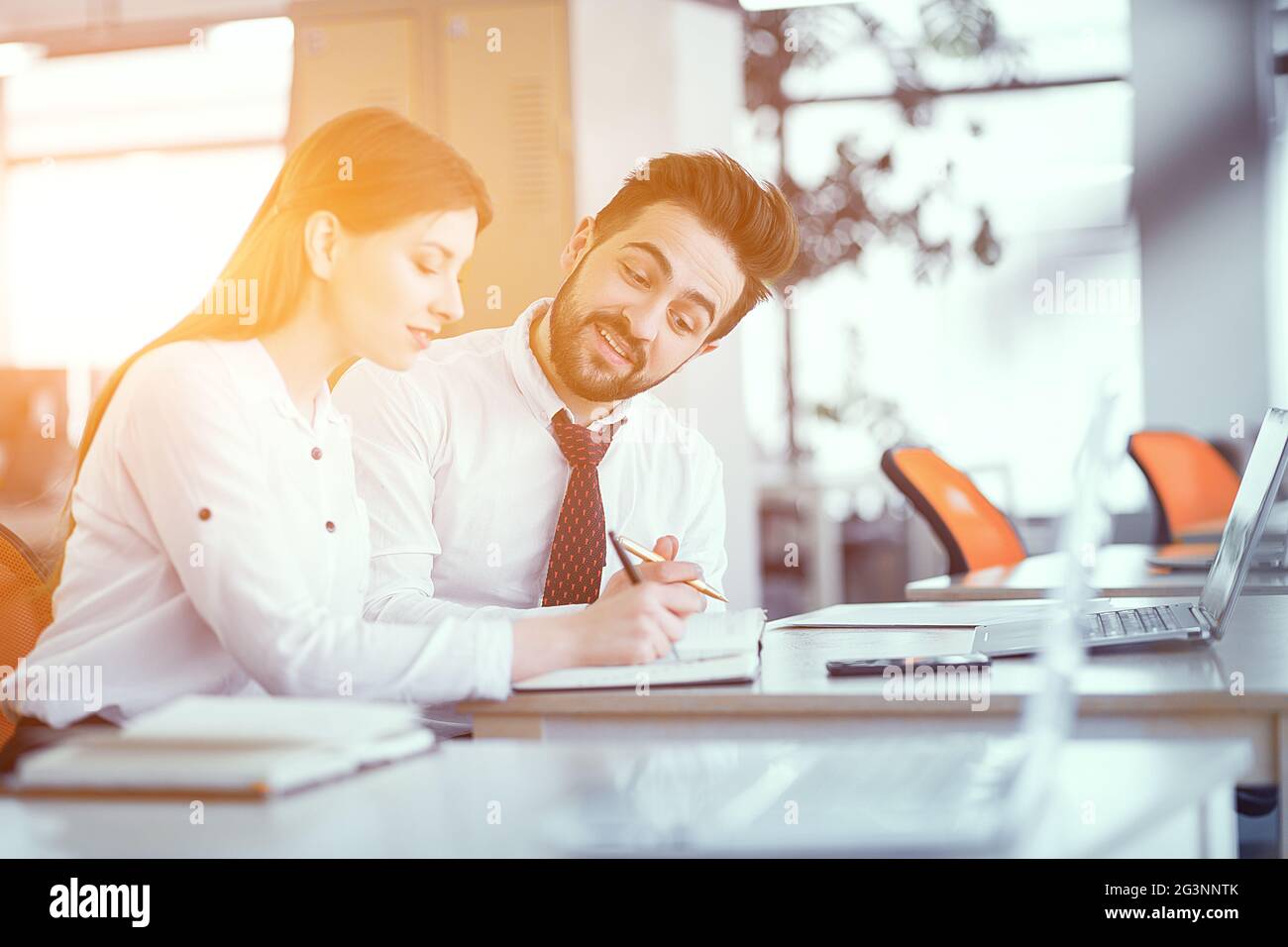 A couple of colleagues at desk in sunny office Stock Photo - Alamy