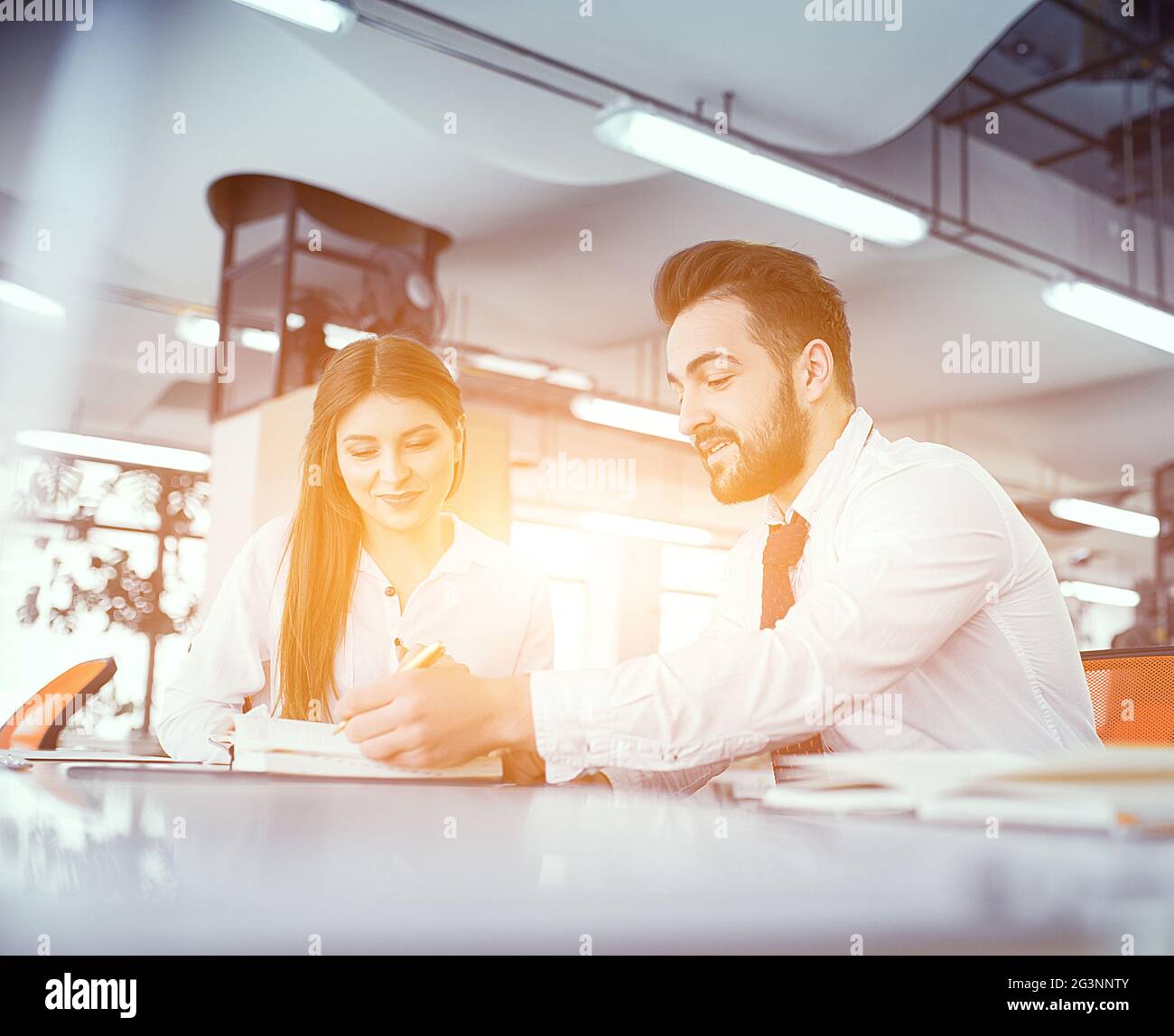 A couple of colleagues at desk in sunny office Stock Photo - Alamy