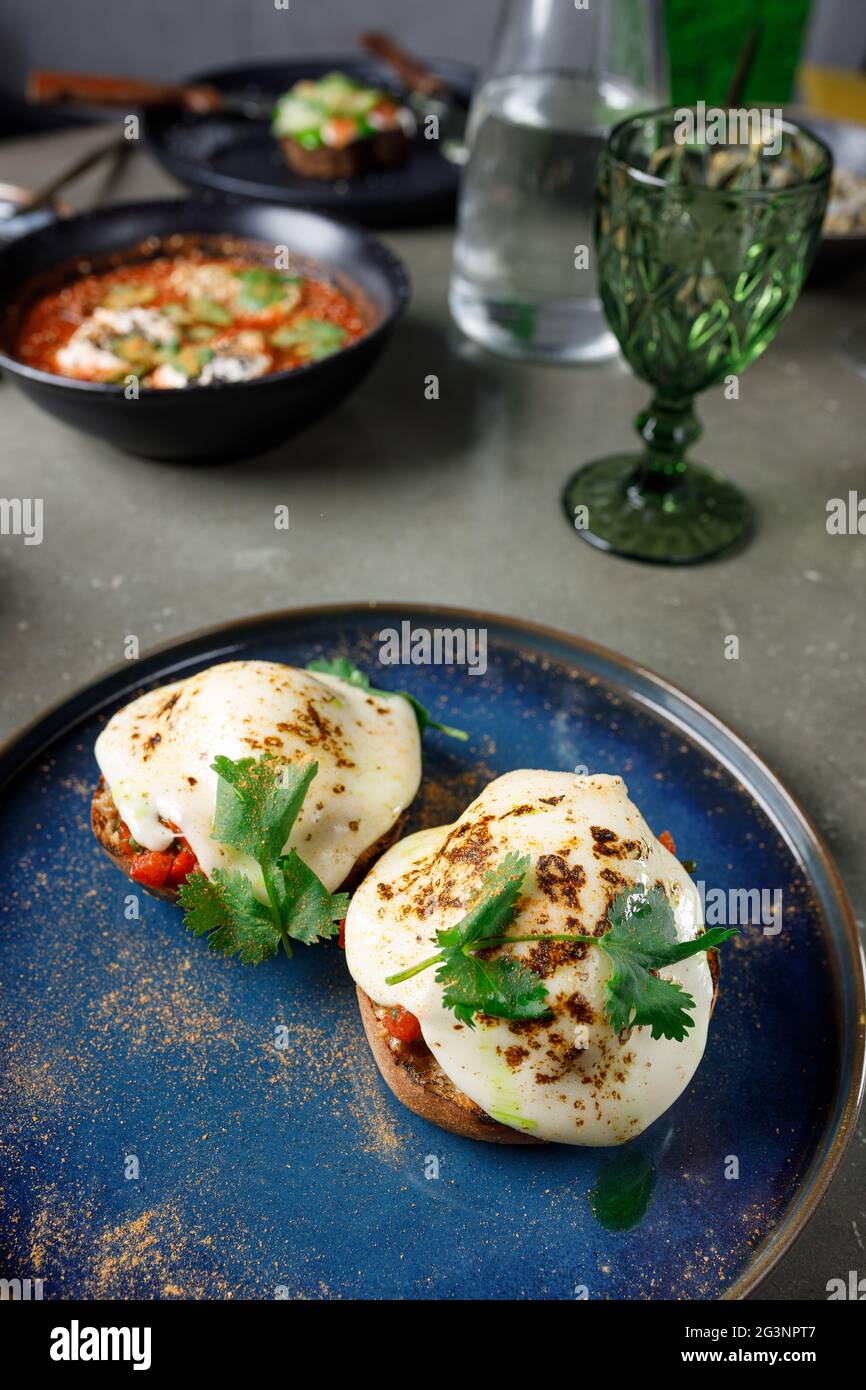 Eggs Benedict with lamb and tomato salsa Stock Photo - Alamy