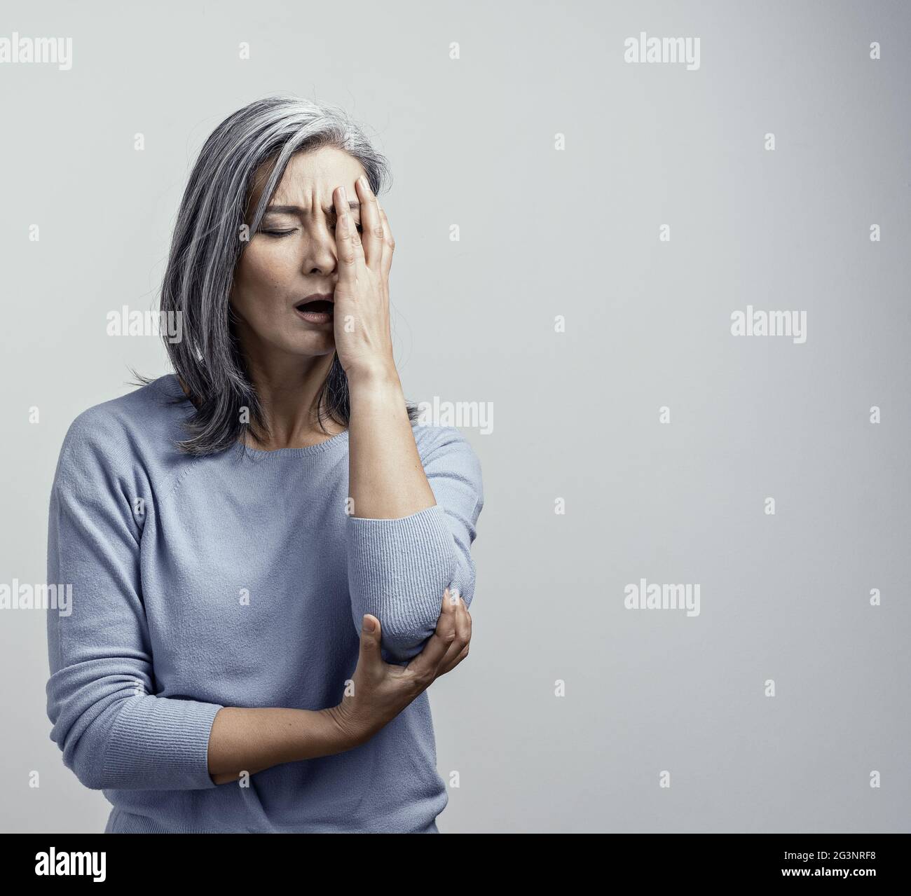 Asian woman in distress on white background Stock Photo - Alamy