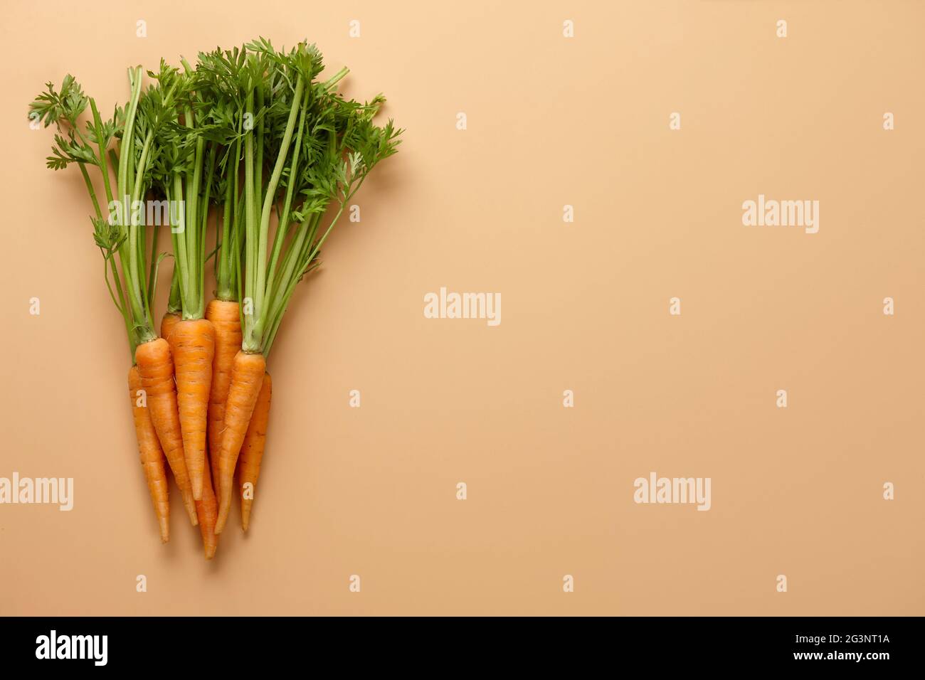 Bunch of fresh carrots on beige background Stock Photo - Alamy