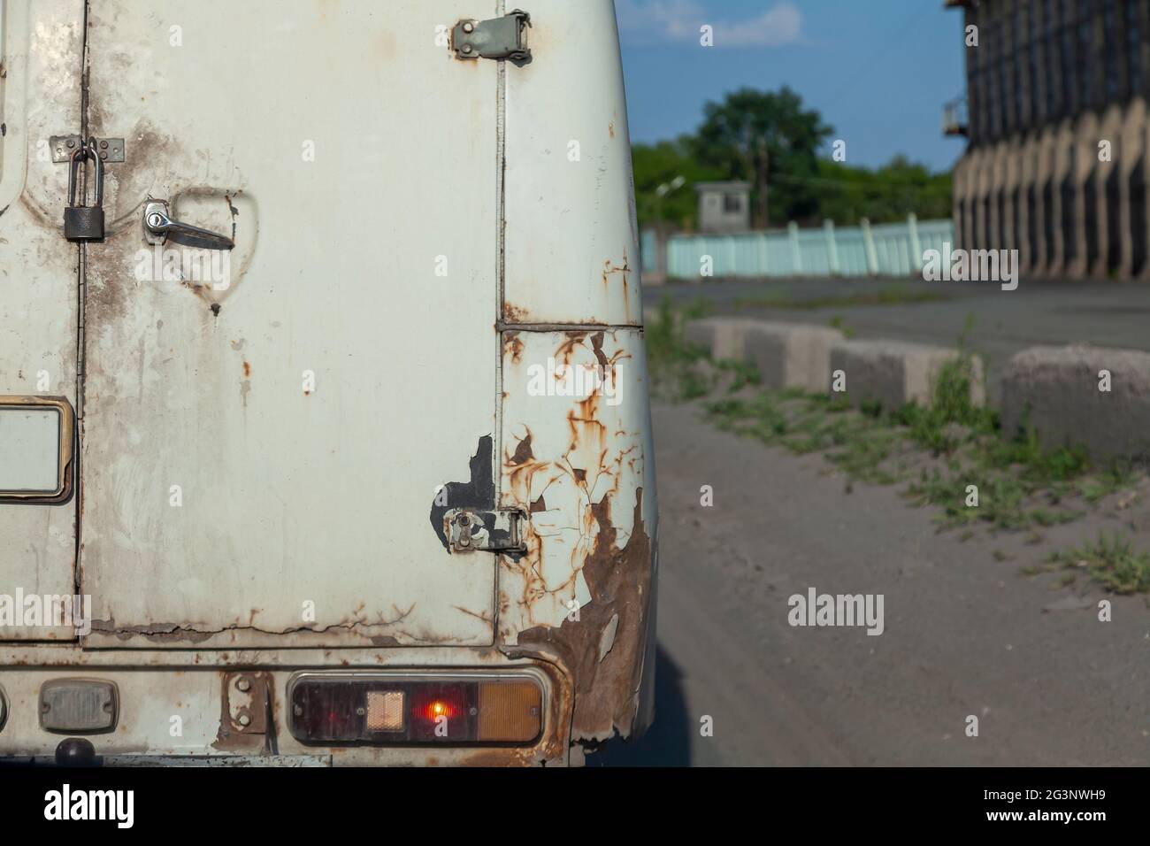 Rusty and bent back of the van. Old rusty bent rear bumper of a car ...