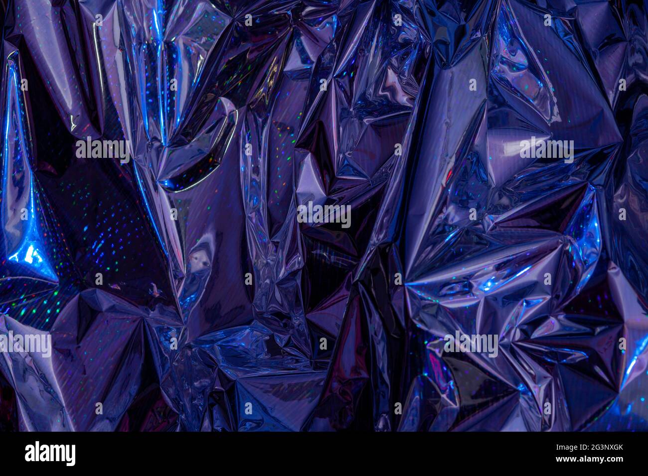 The background of crumpled holographic packaging film with an abstract ...