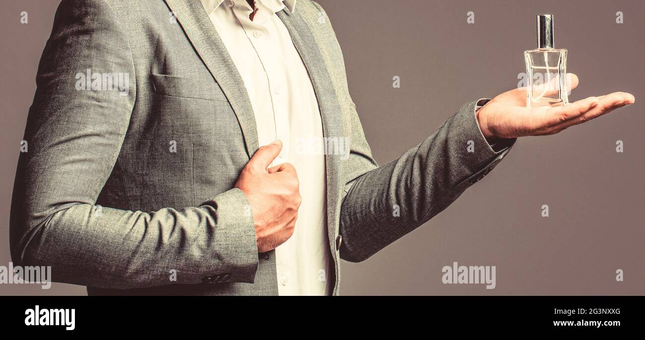 Man holding up bottle of perfume. Men perfume in the hand on suit ...