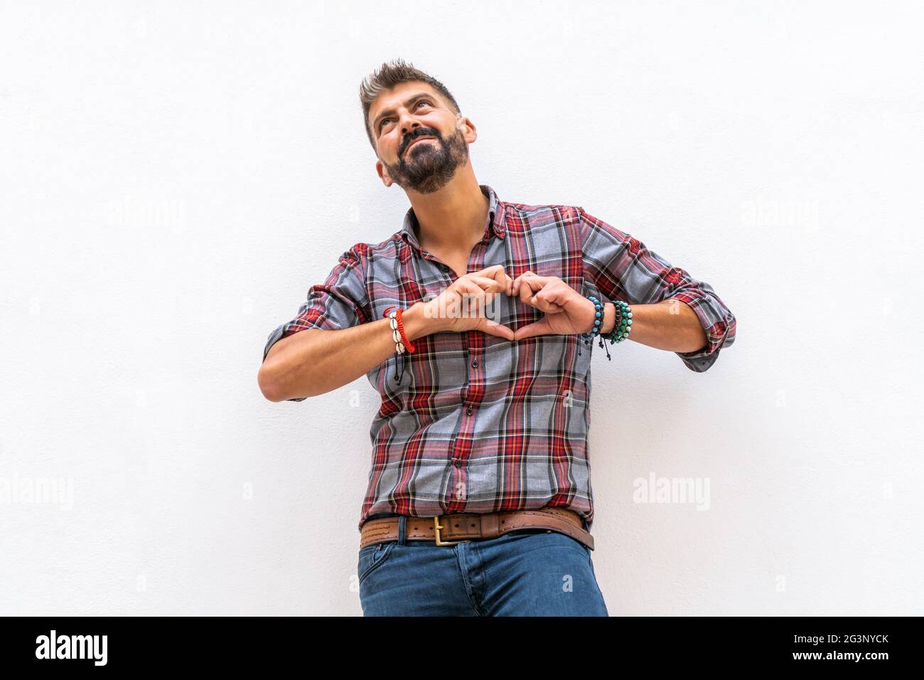 Handsome young man making heart sign with his hands fingers hi-res ...