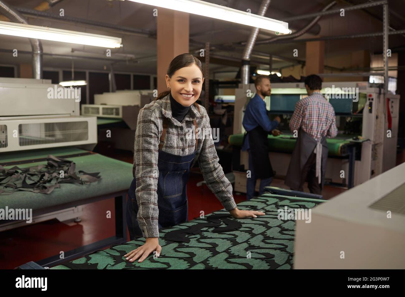 Female worker standing in leather cutting workshop of footwear ...