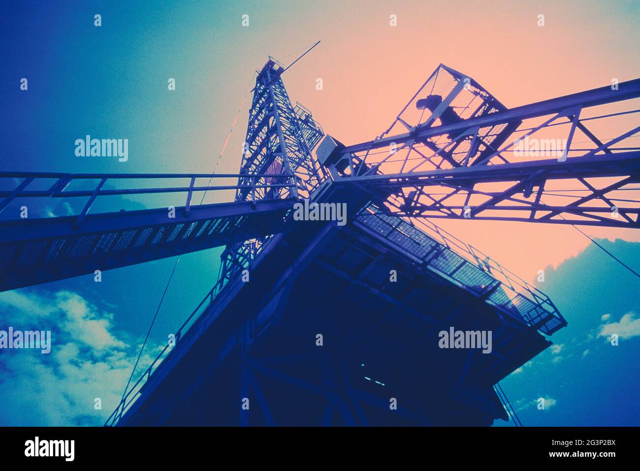 oil field worker rides elevator to rig floor at sunset, SE USA Stock ...
