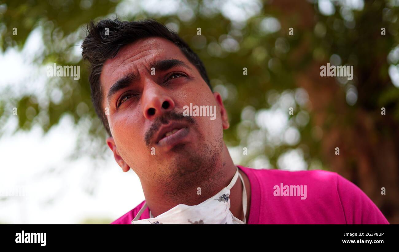 Handsome Asian man wearing red shirt over blur background with serious ...