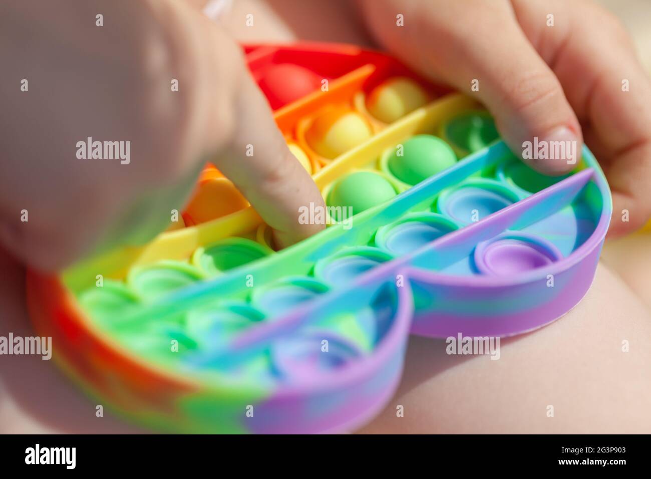Baby fingers and antistress toy - popit, simple dimple Stock Photo - Alamy
