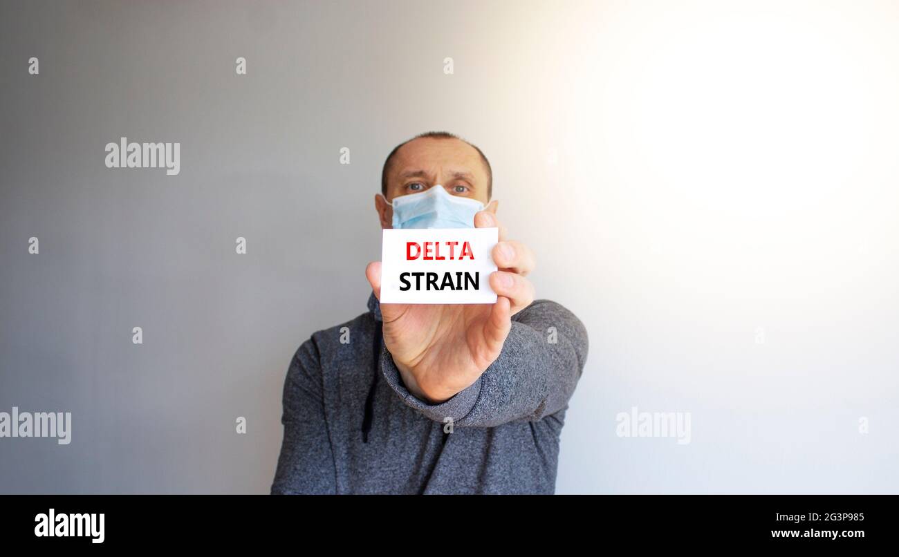 COVID-19 delta strain symbol. White card with words 'delta strain'. A ...