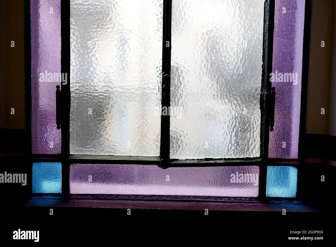 Purple, white and blue glass window, on historical building staircase ...