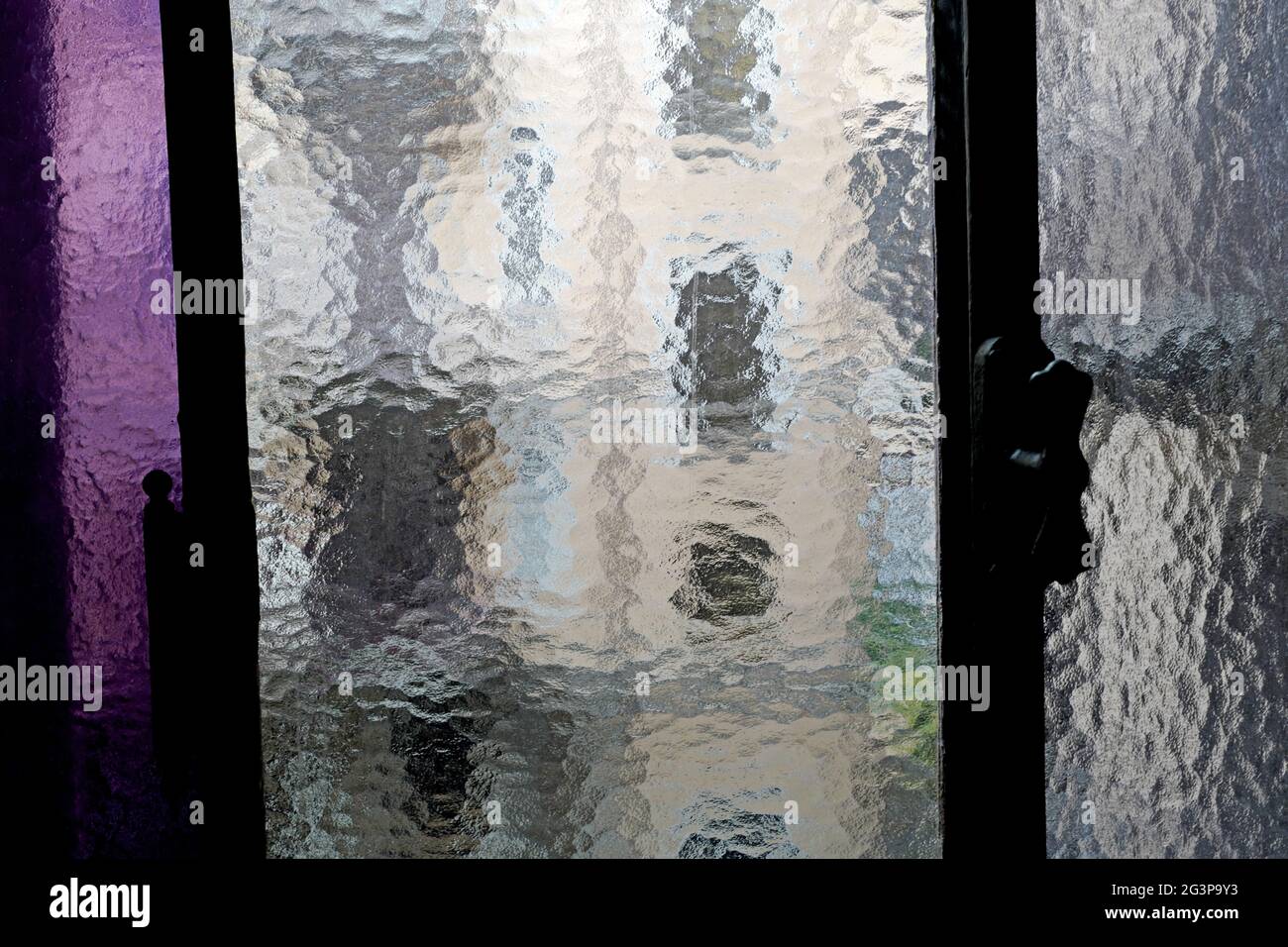 Purple, white and blue glass window, on historical building staircase ...