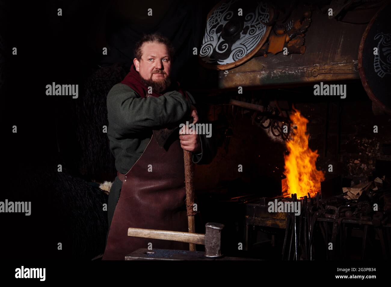 Viking forges weapons and swords in the smithy. A man in a warrior's ...