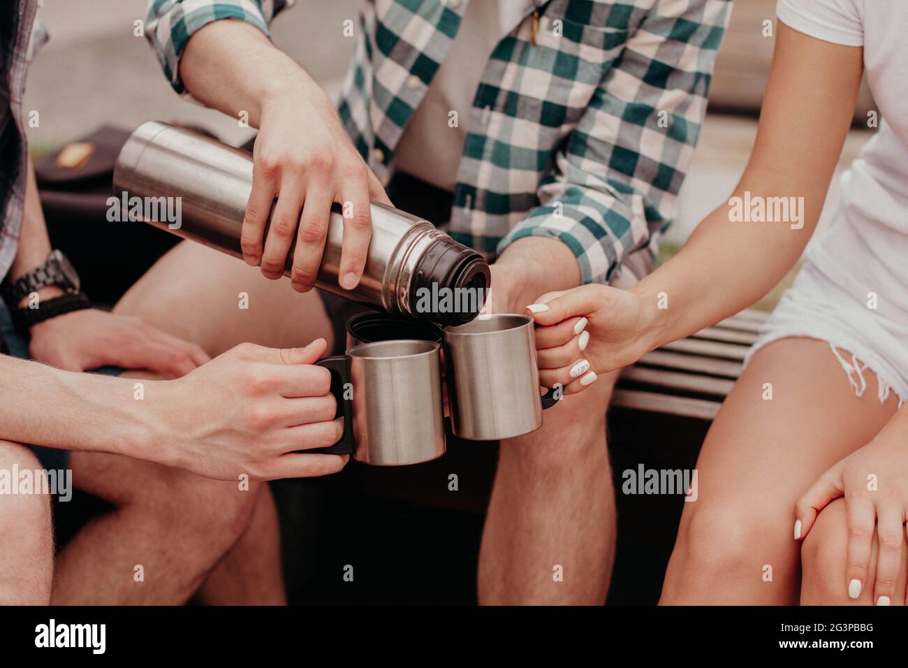 Tea Party On The Street. Three Young Students Pour Tea From A Thermos ...