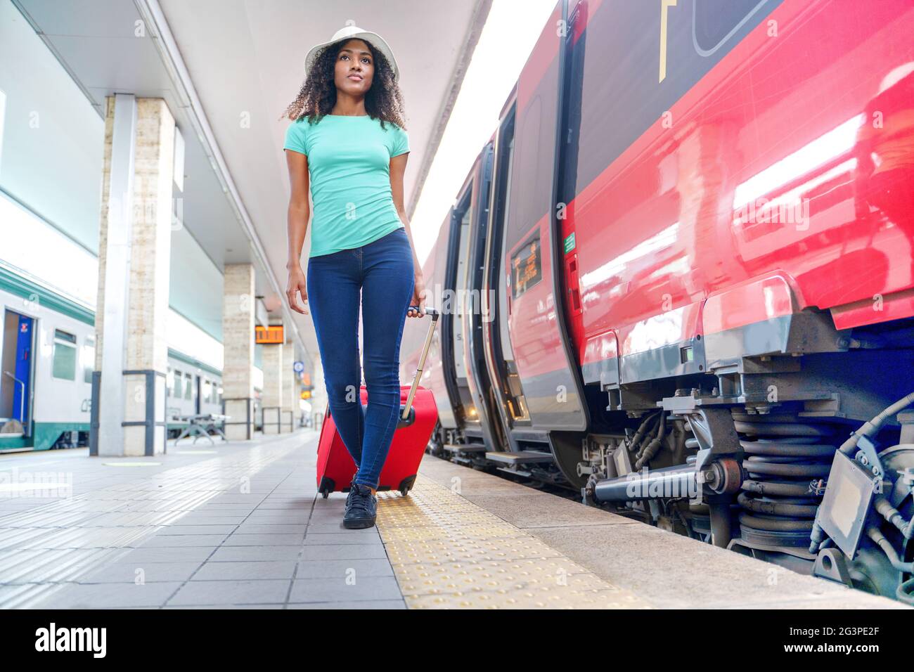 Afro woman ready to take the train with carry on baggage trolley Stock ...