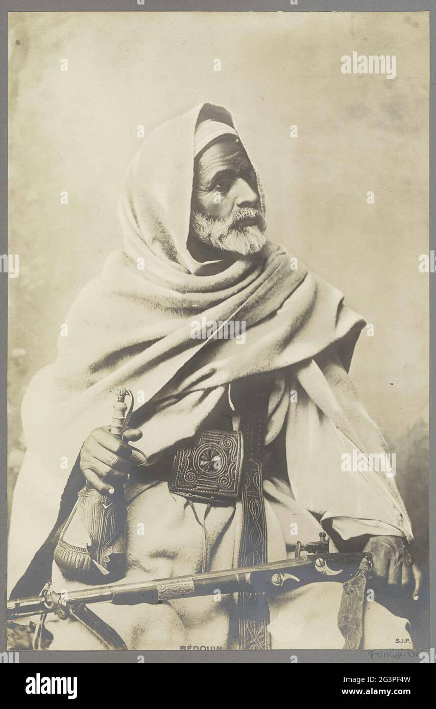 Portrait of a Bedouin with rifle on lap; Bédouin. Part of travel album ...