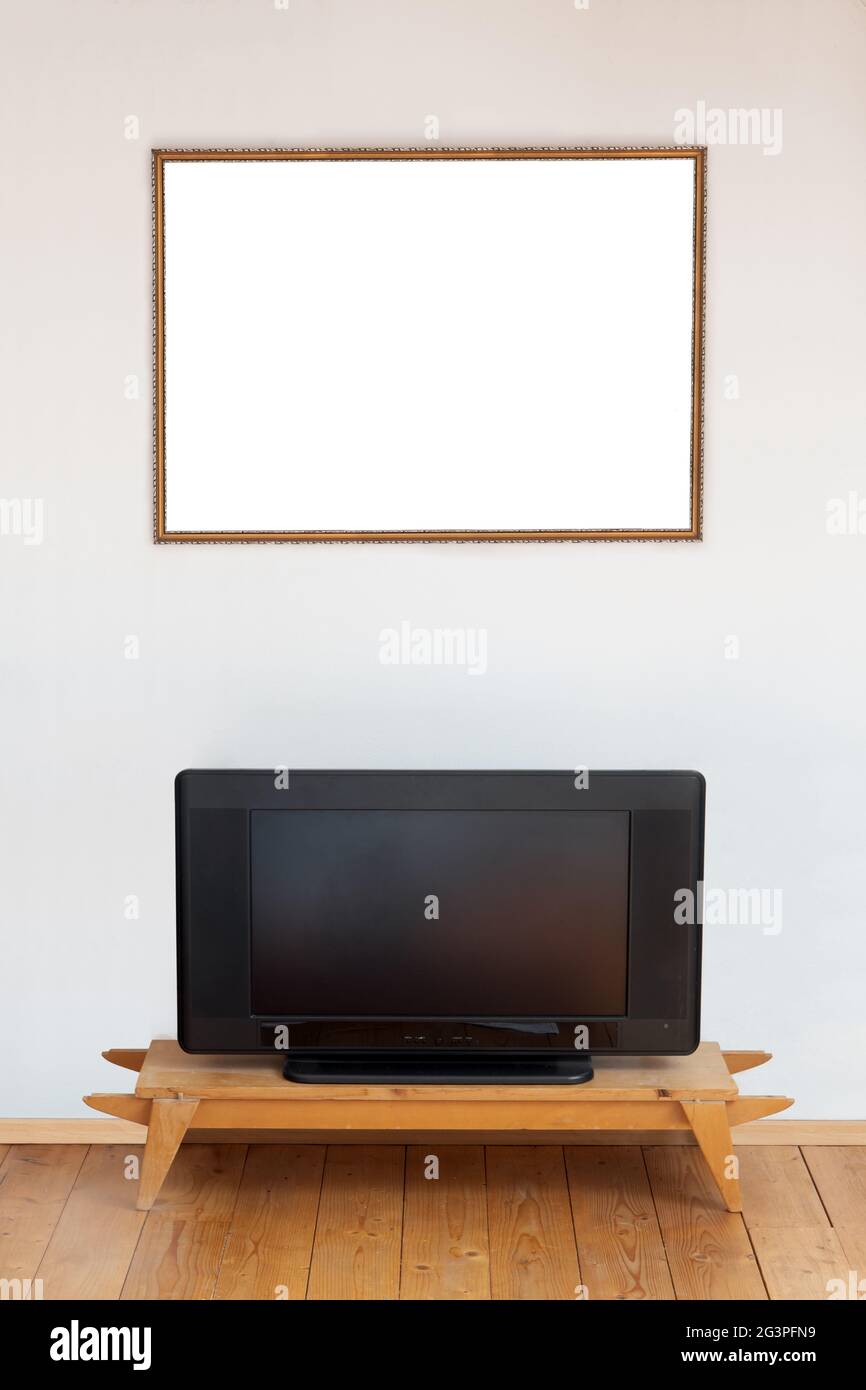 An Older television on a wooden table under a frame with empty space ...