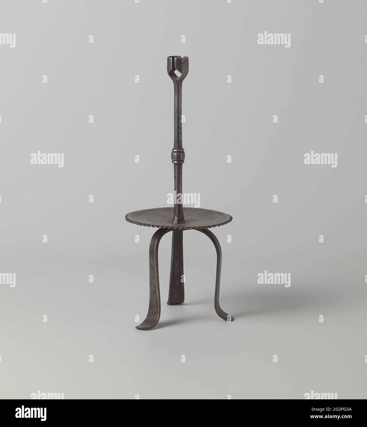 Candlestick of iron on three legs. Iron candlestick. The round fat ...