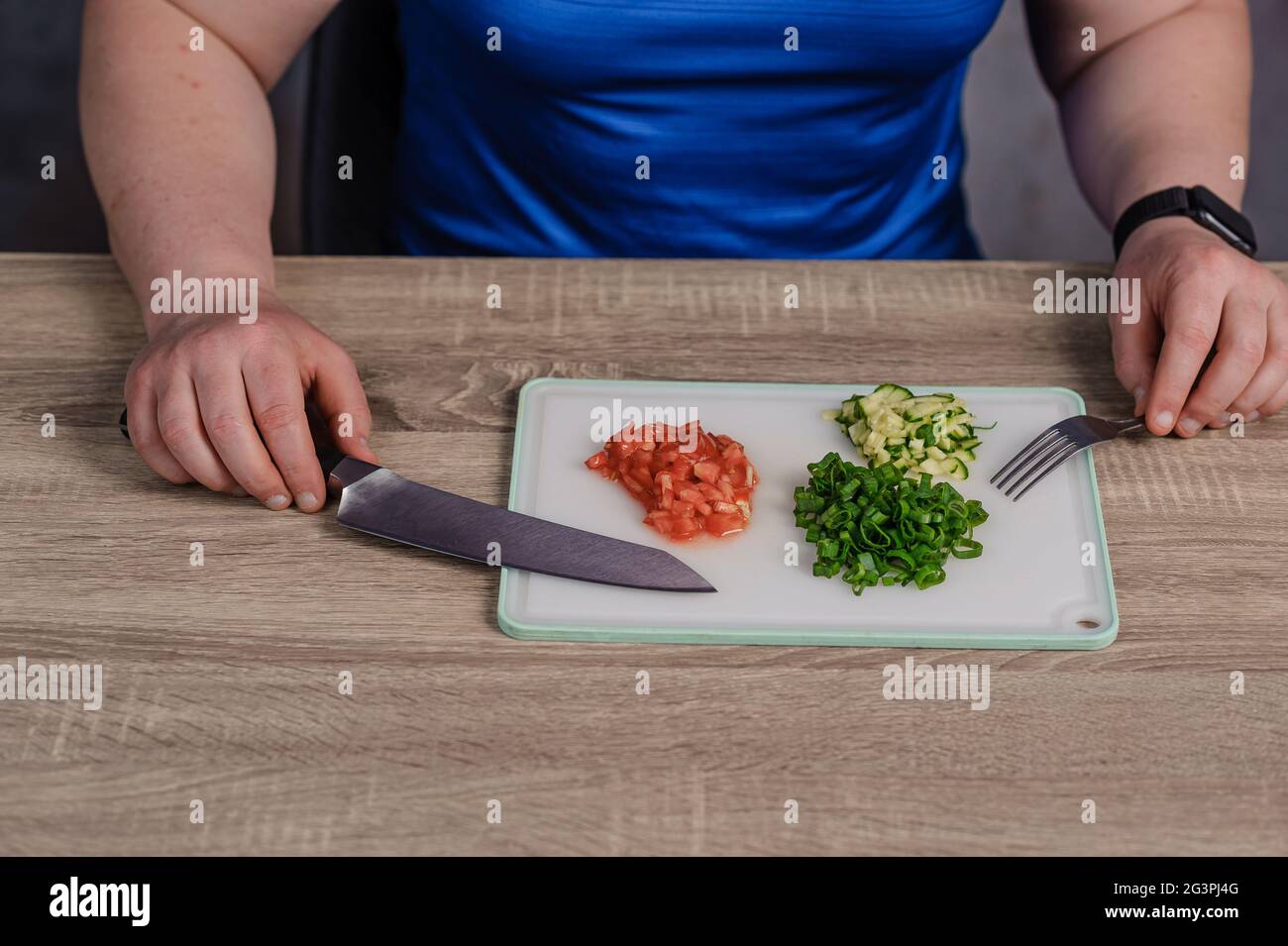 A man cuts green onions on a board. Healthy eating Stock Photo - Alamy